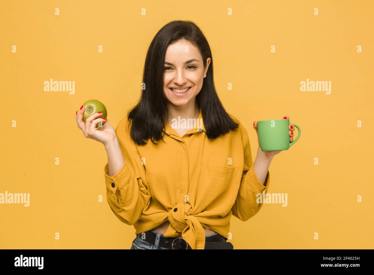Concept photo of young female eating apple and drinking something ...