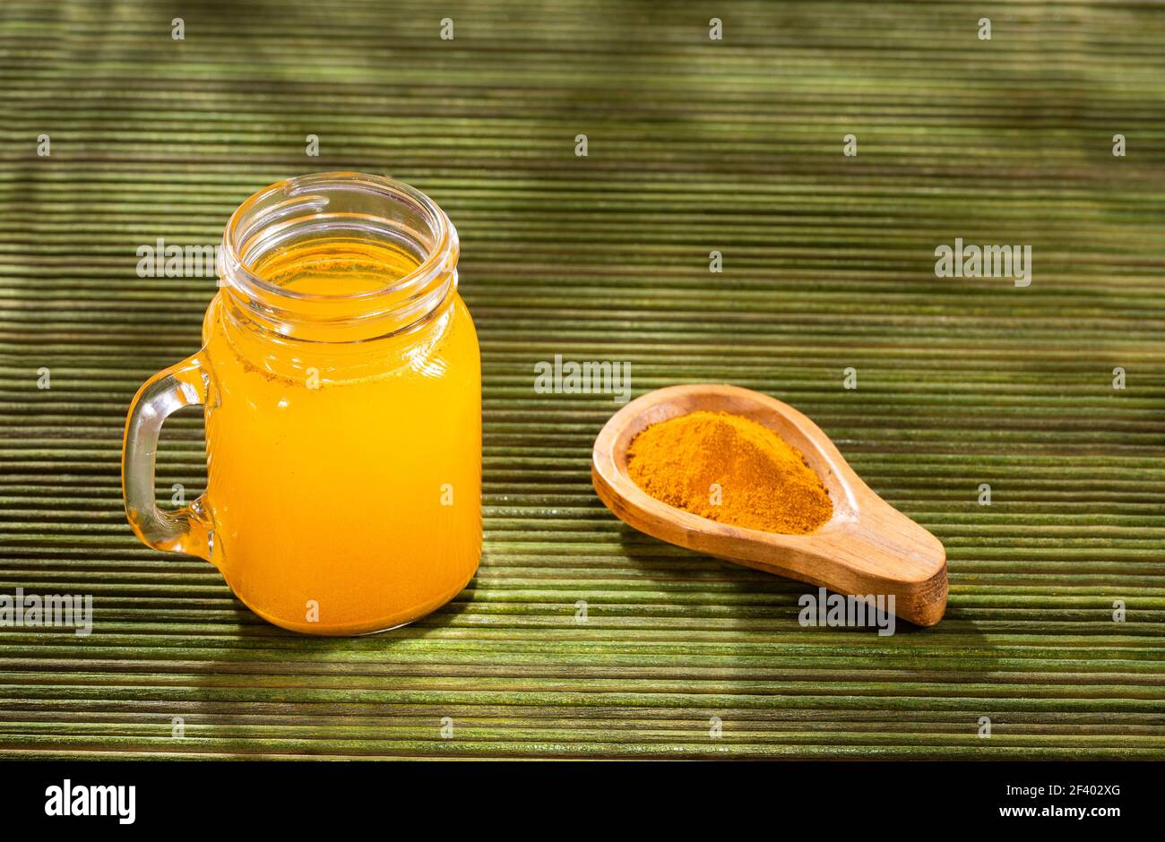Spoon with turmeric powder to mix with water - Curcuma longa Stock ...
