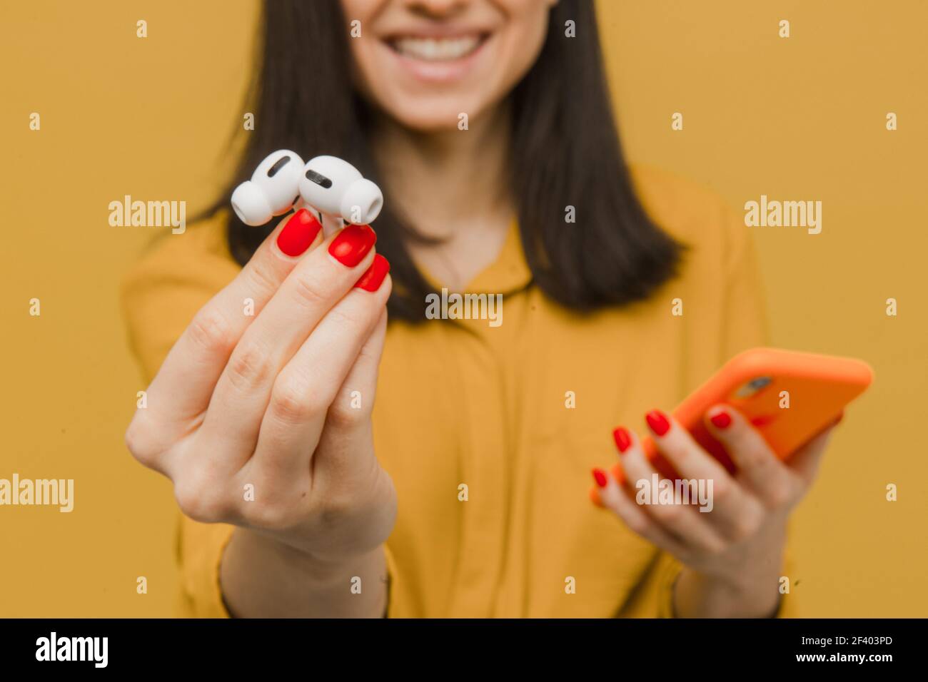 Close up photo of young female holds EarPods and smartphone looks so ...