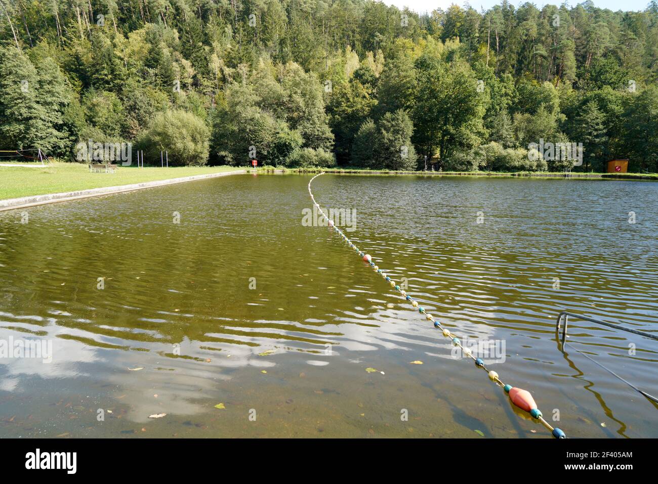 Natural swimming pool in the forest in Bavaria in summer photographed ...