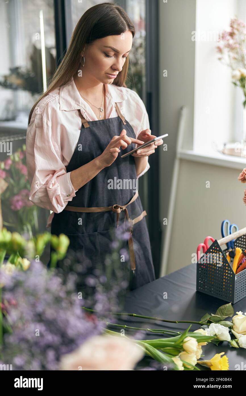 Photo of successful modern florist wearing apron making picture of ...