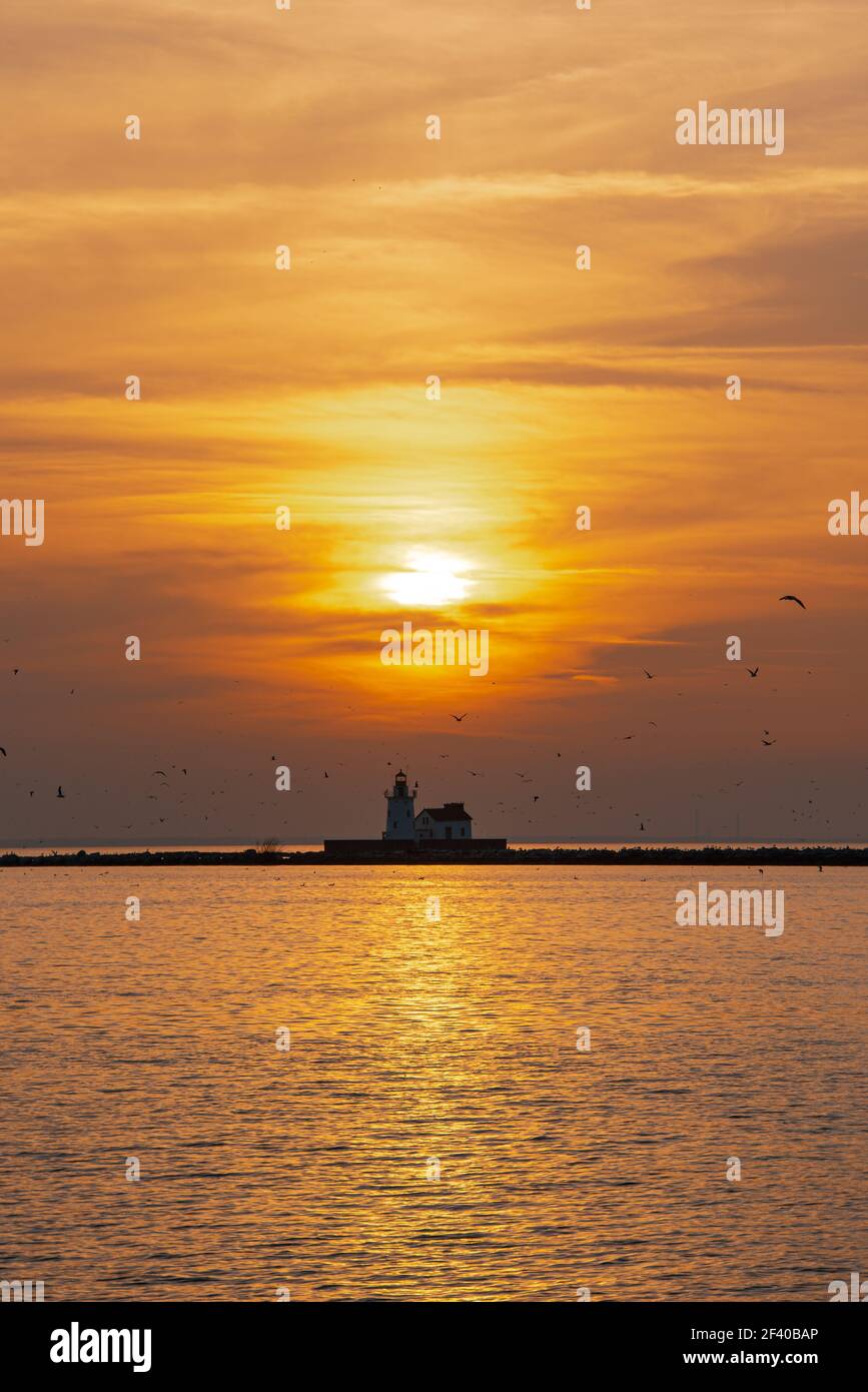 Sunset with a lighthouse Stock Photo - Alamy