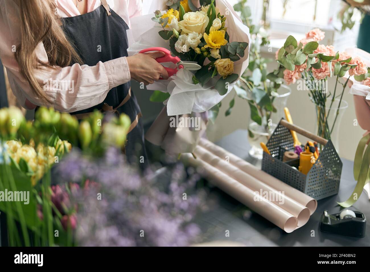 Portrait of successful modern florist wearing apron, creating beautiful ...