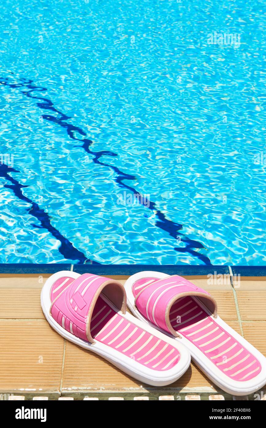 A pair of womens plastic sandals by side of swimming pool Stock Photo ...
