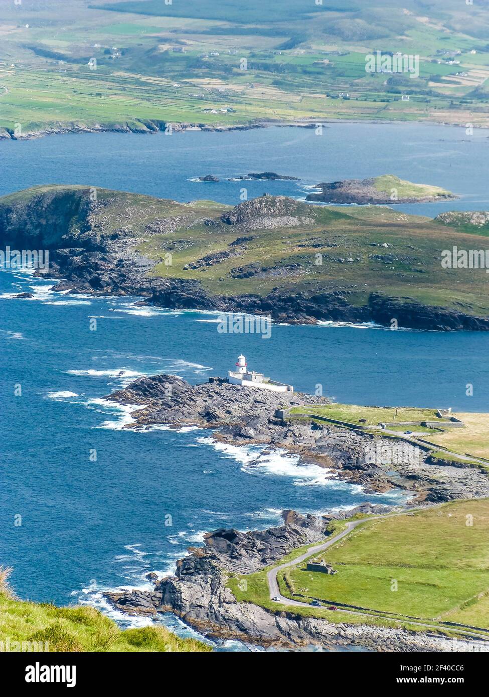 lighthouse on rocks in the ocean in amazing ireland landscape Stock ...