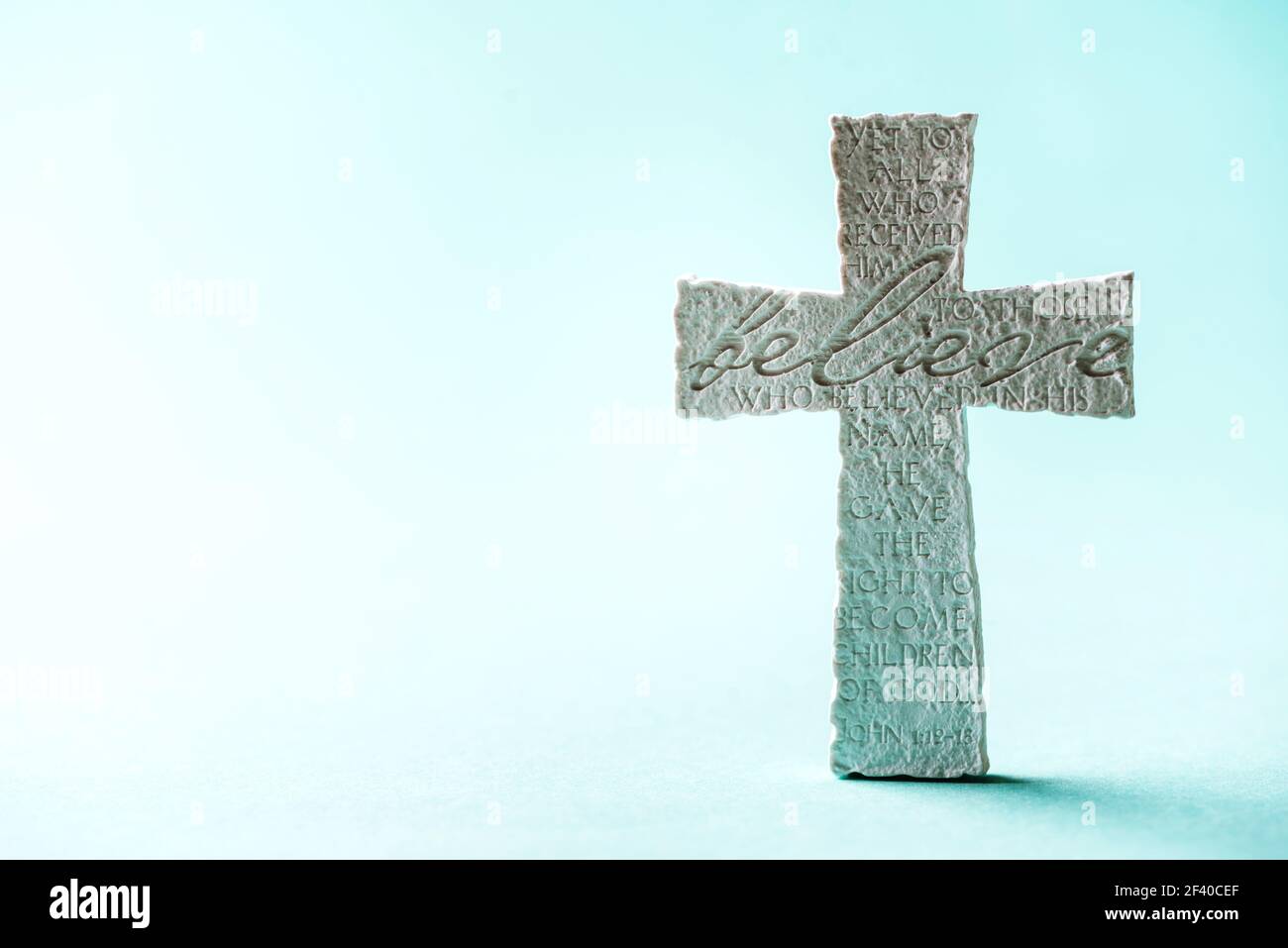 Stone cross with inscription Believe on blue background, Copy space ...