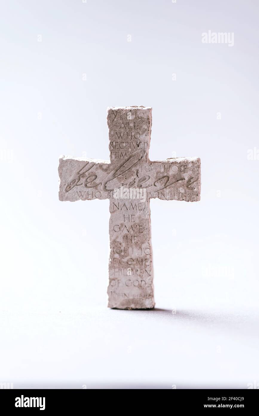 Stone cross with inscription Believe on grey background, Copy space ...