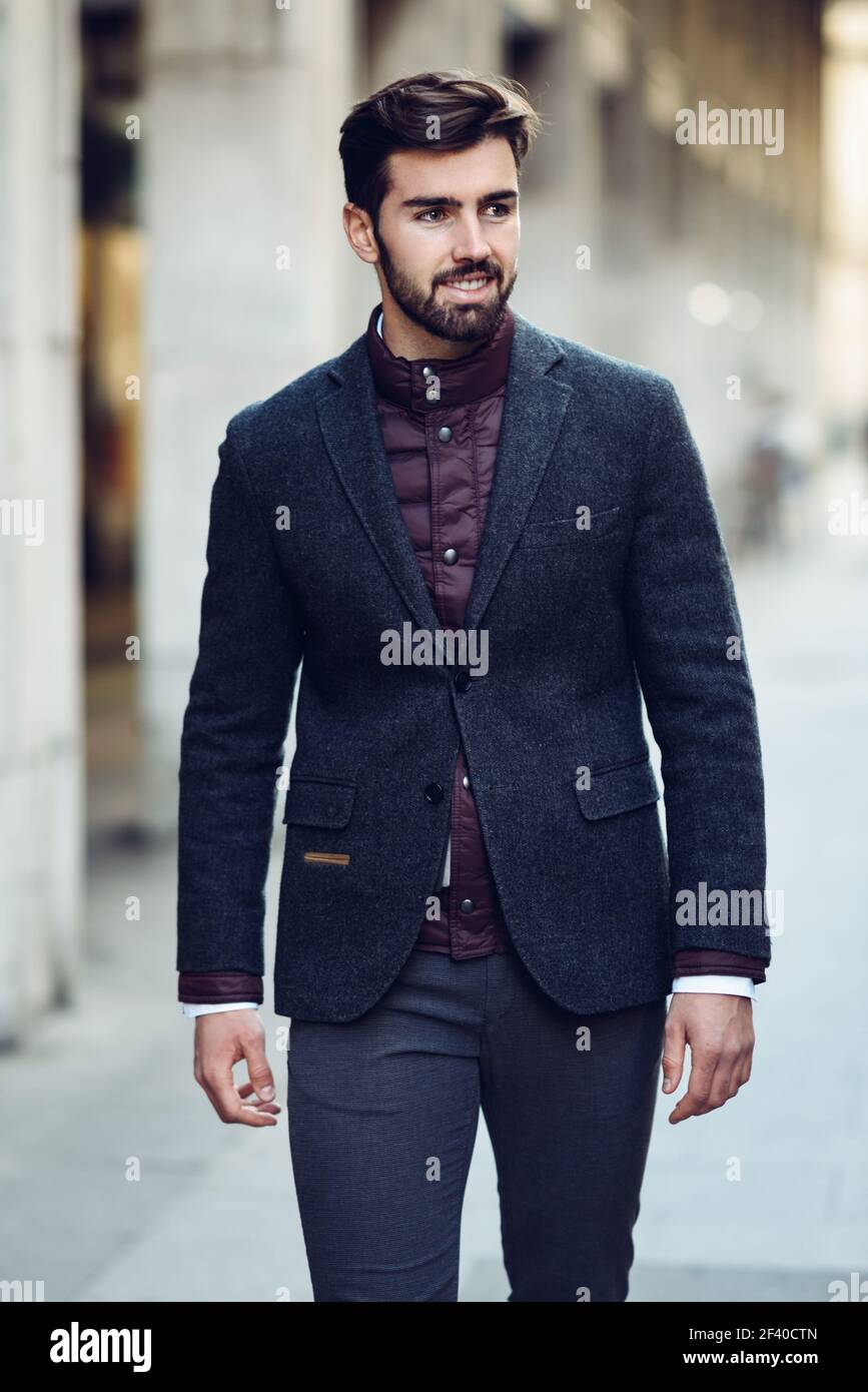 Young bearded man, model of fashion, smiling in urban background wearing british elegant suit ...