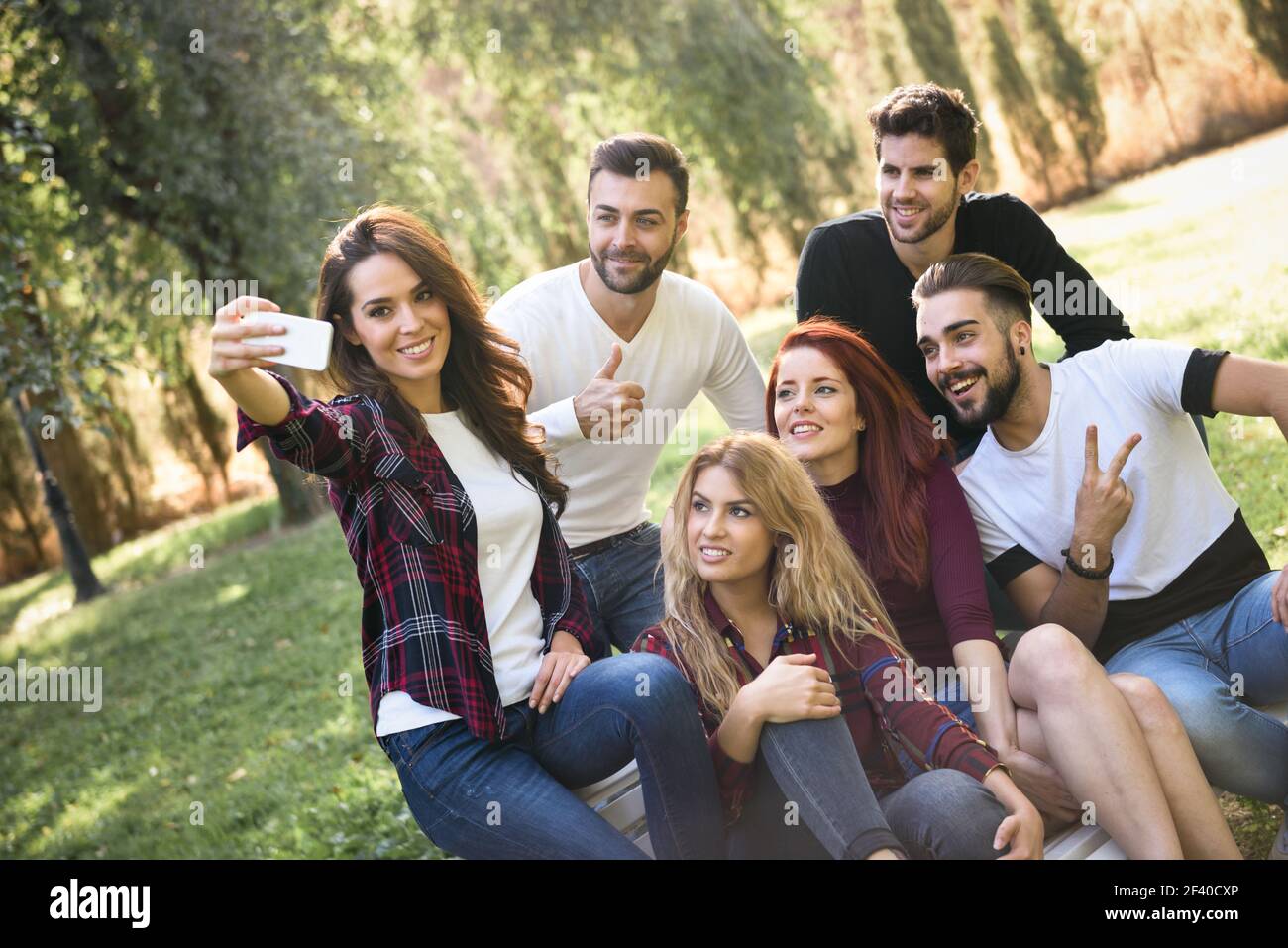 Group of friends taking selfie in urban park. Five young people wearing ...
