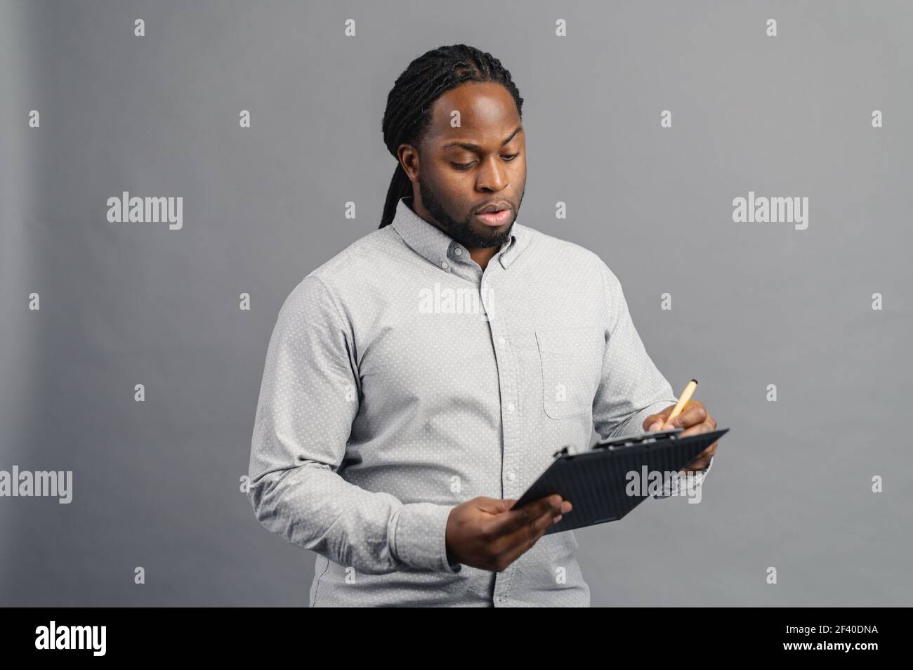 Concentrated African-American young man with dreadlocks holding a ...