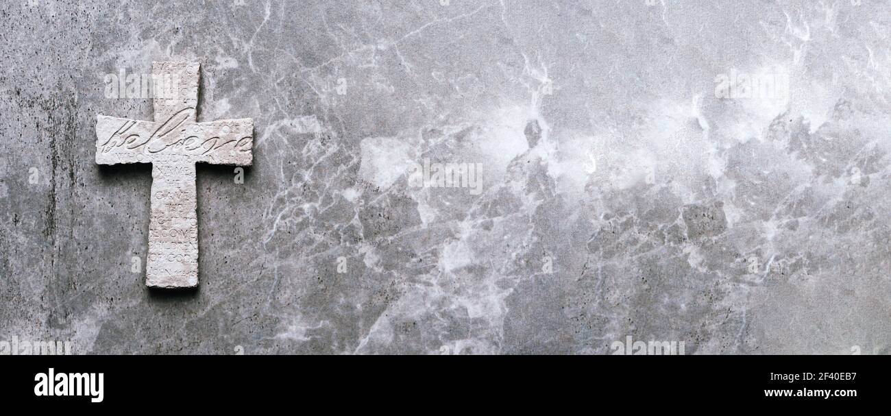 Stone cross with inscription Believe on grey background, Copy space ...