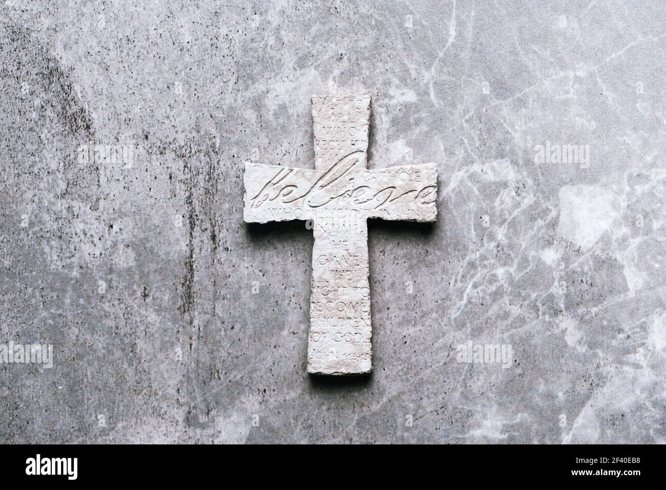 Stone cross with inscription Believe on grey background, Copy space ...