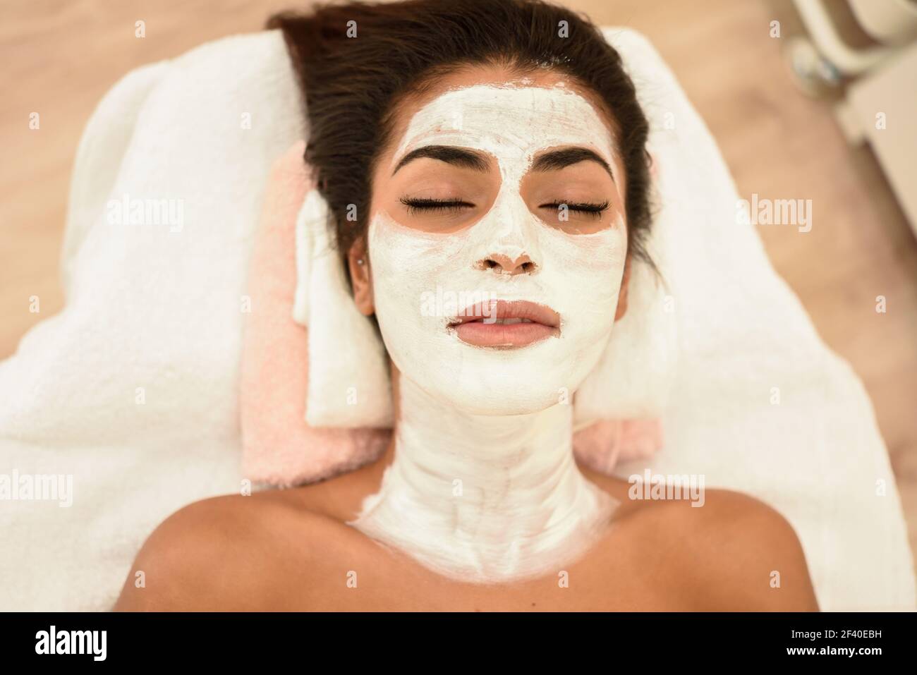 Young woman with moisturizer cream mask on her face in modern wellness ...