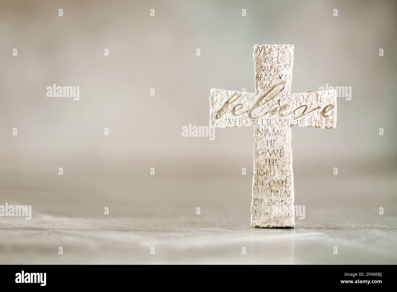 Stone cross with inscription Believe on grey background, Copy space ...