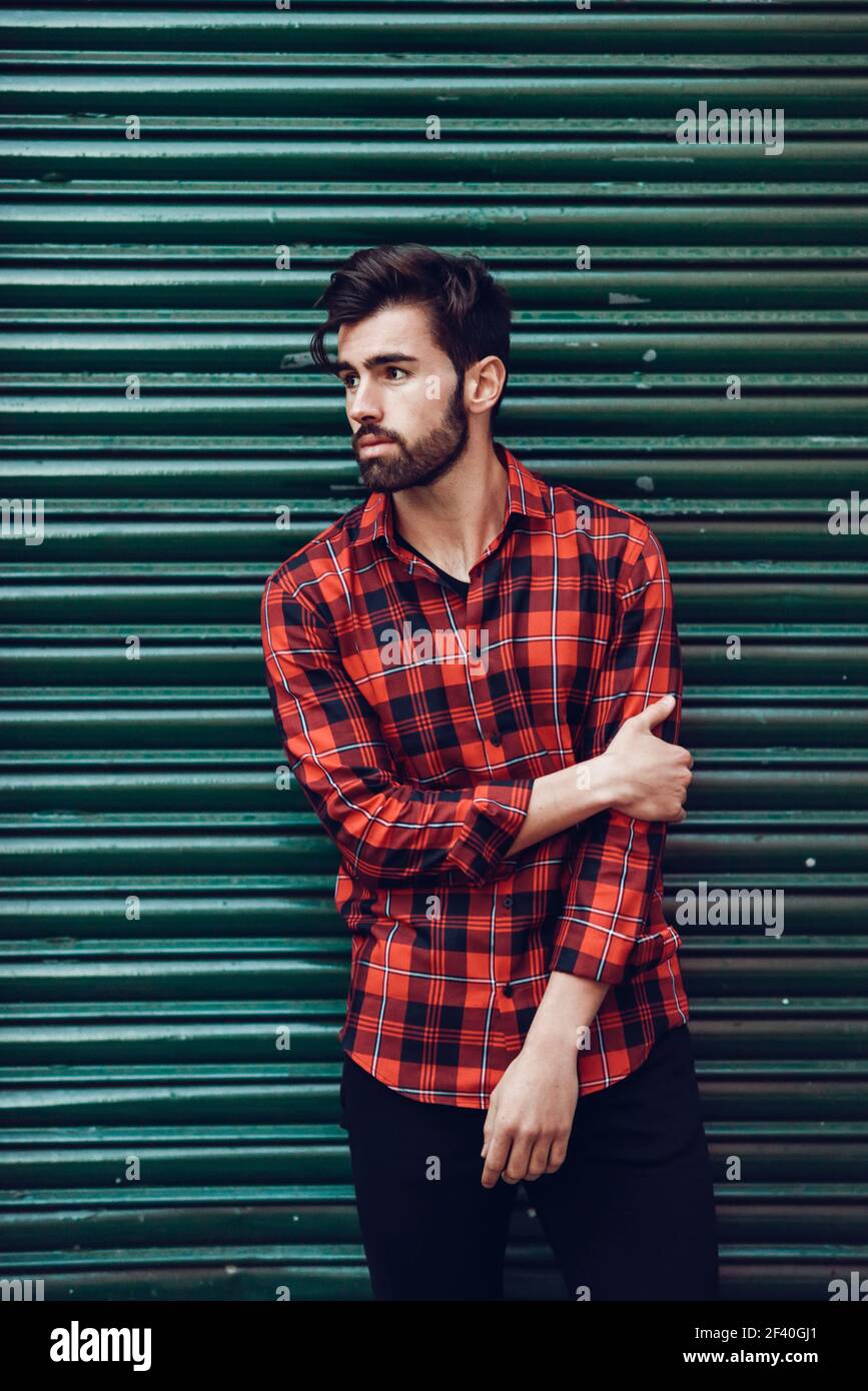 Young bearded man, model of fashion, wearing a plaid shirt with a green ...