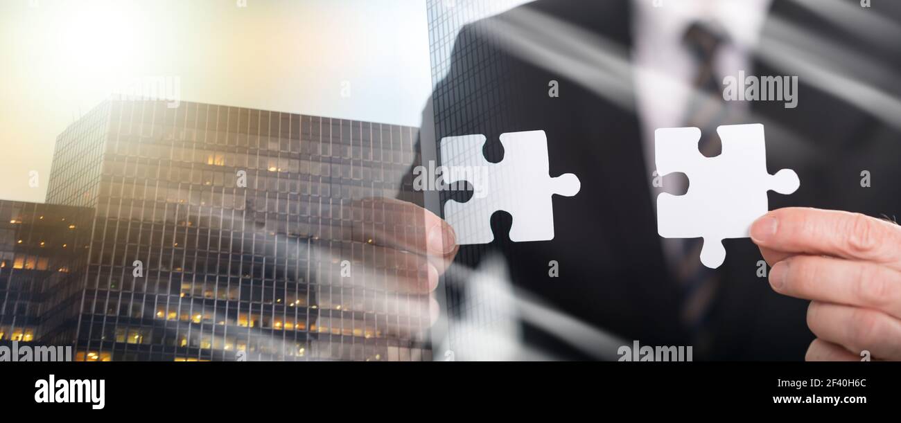 Hands joining two puzzle pieces, teamwork concept; multiple exposure ...