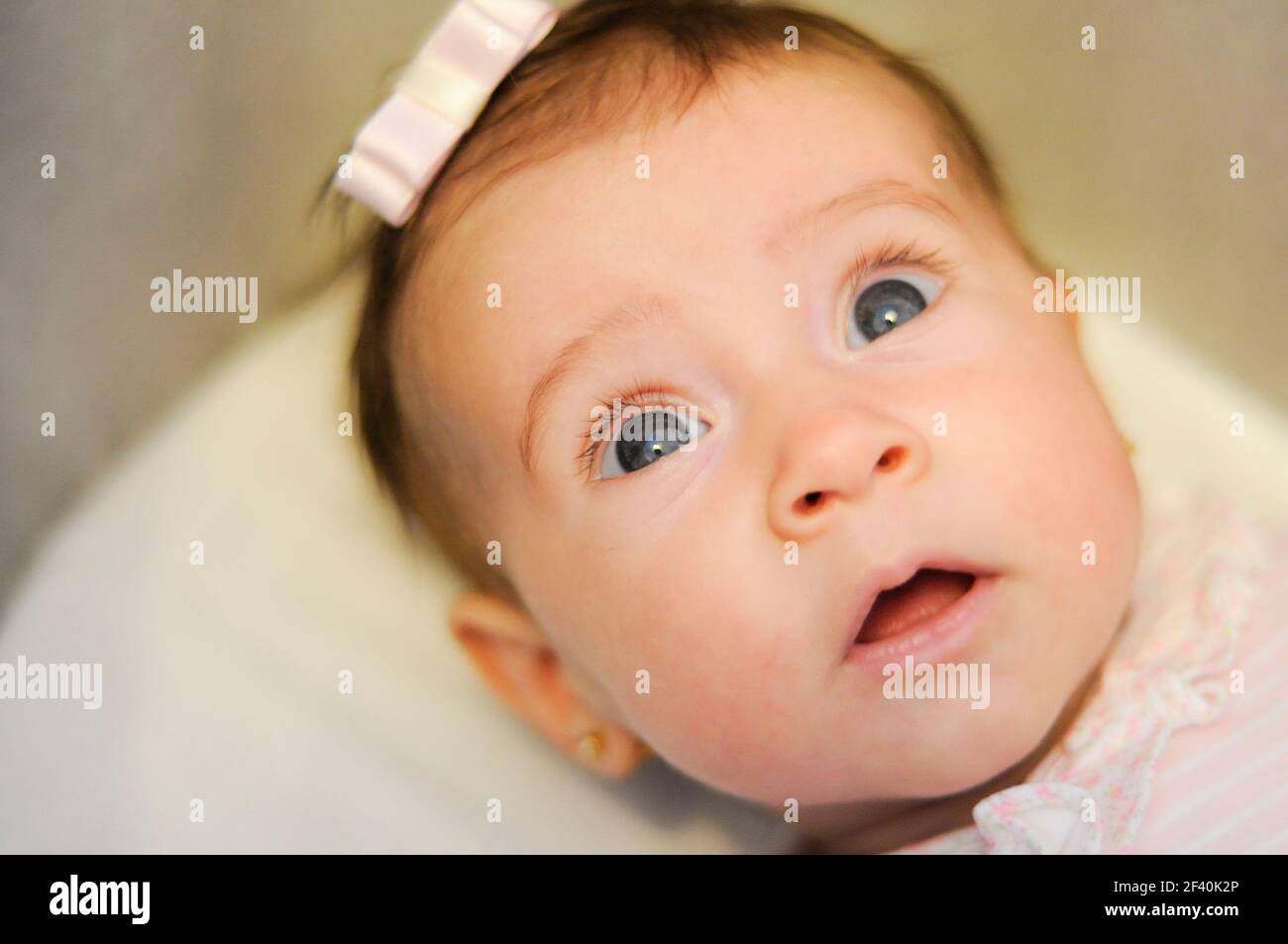 Little baby girl with funny surprise expression on her face. Two months ...