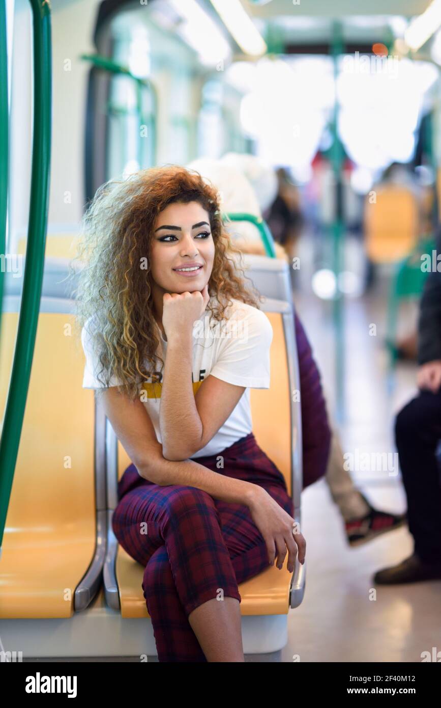 Arabic woman sitting inside subway train. Arab girl in casual clothes ...