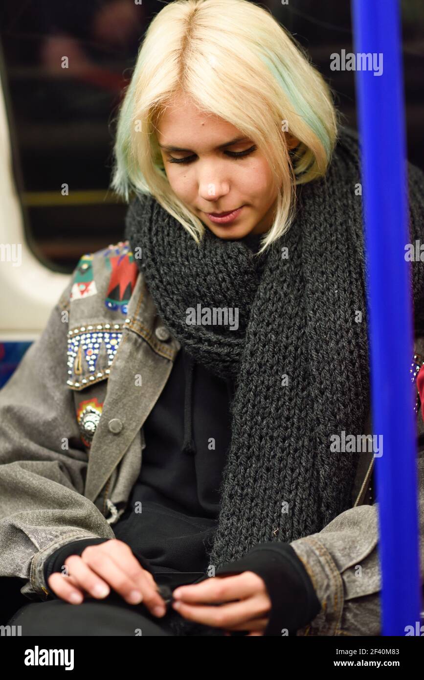 Young woman with short hair sitting inside underground wagon in London ... Young woman with short hair sitting inside underground wagon in London ...