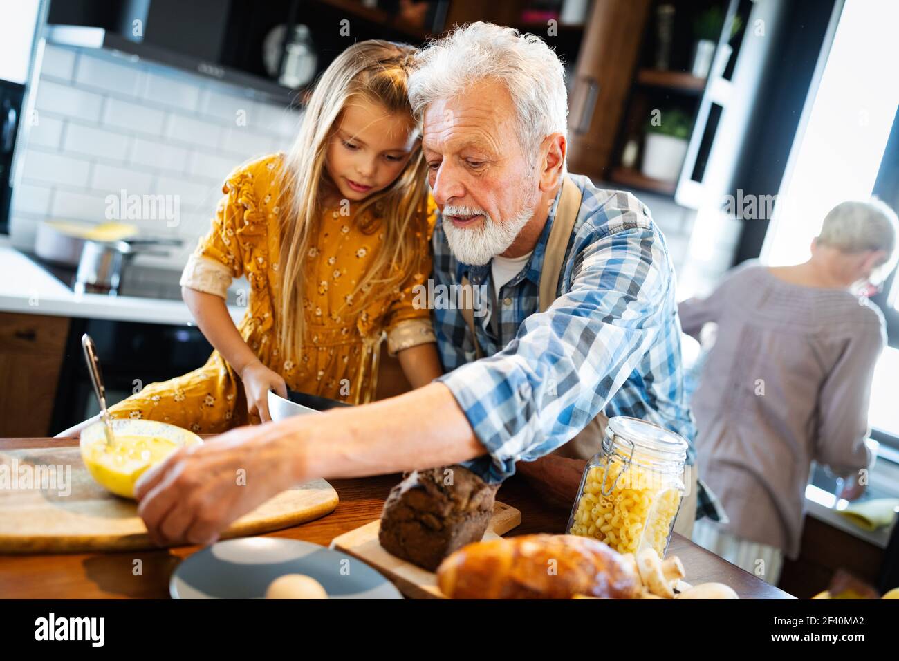 Smiling grandparents having breakfast with their granddaughter Stock ...