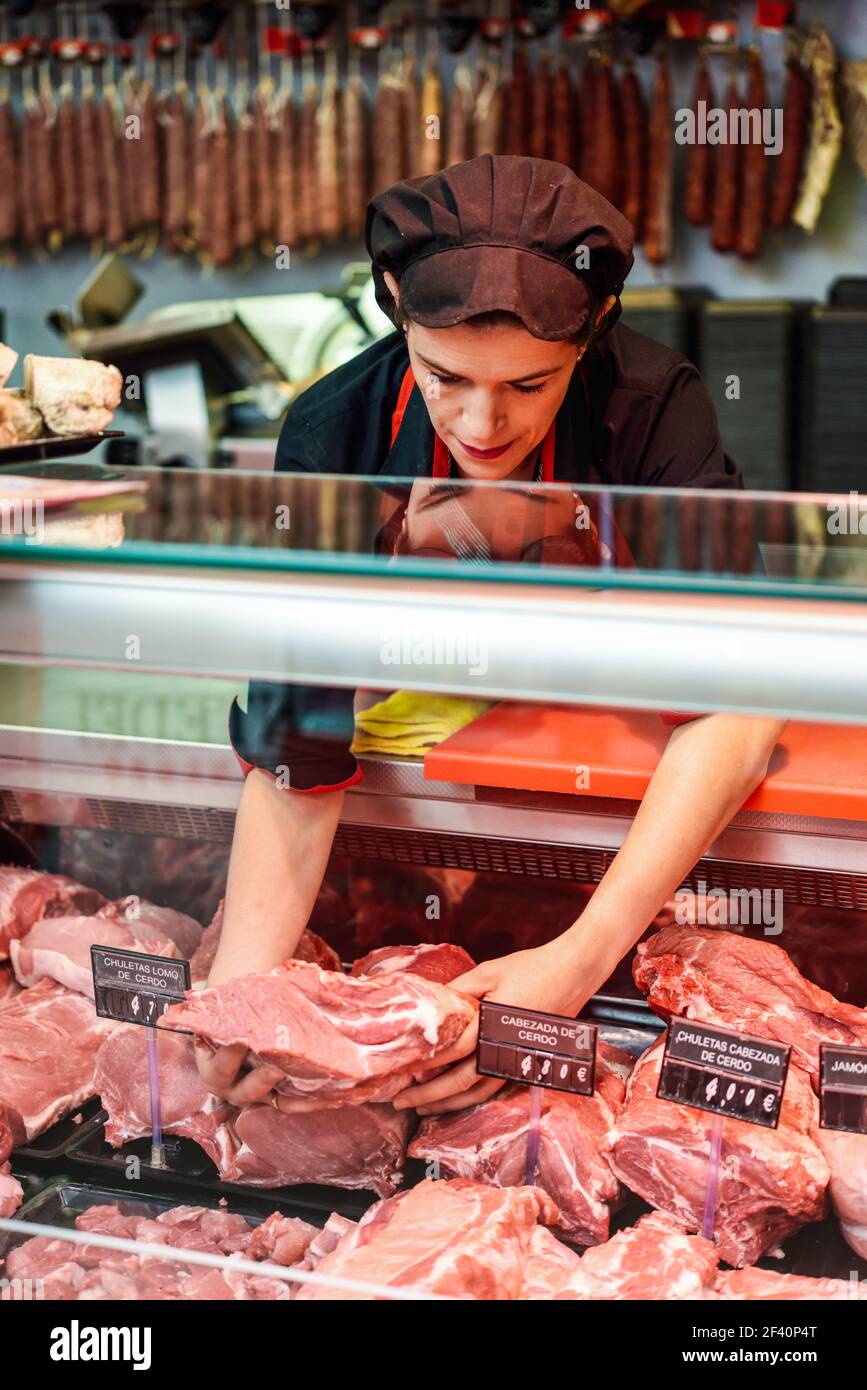 Female butcher’s hands holding meat piece in shop. Butcher’s hands ...