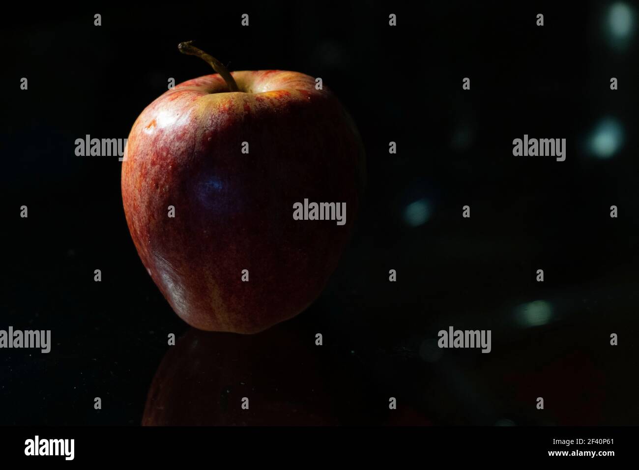 red apple in the shadow against black background Stock Photo - Alamy