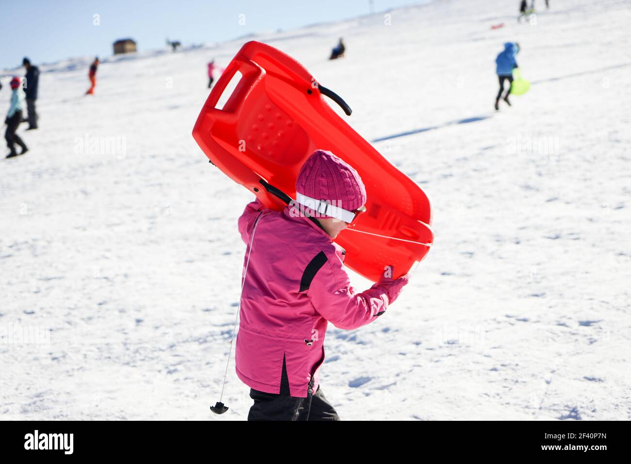 Little girl sledding at Sierra Nevada ski resort wearing snow clothes ...