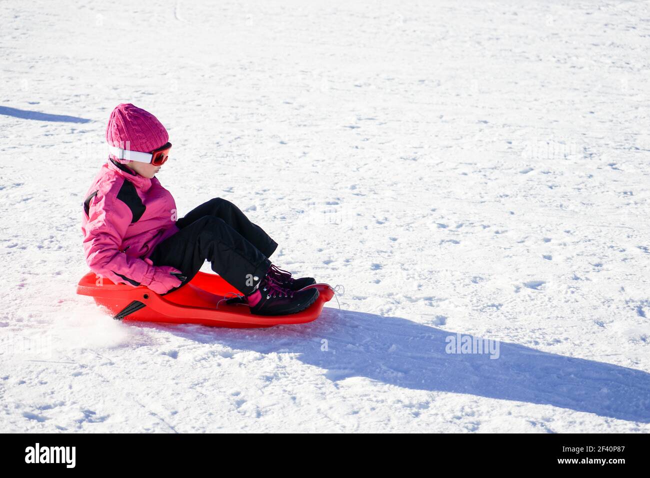 Little girl sledding at Sierra Nevada ski resort wearing snow clothes ...