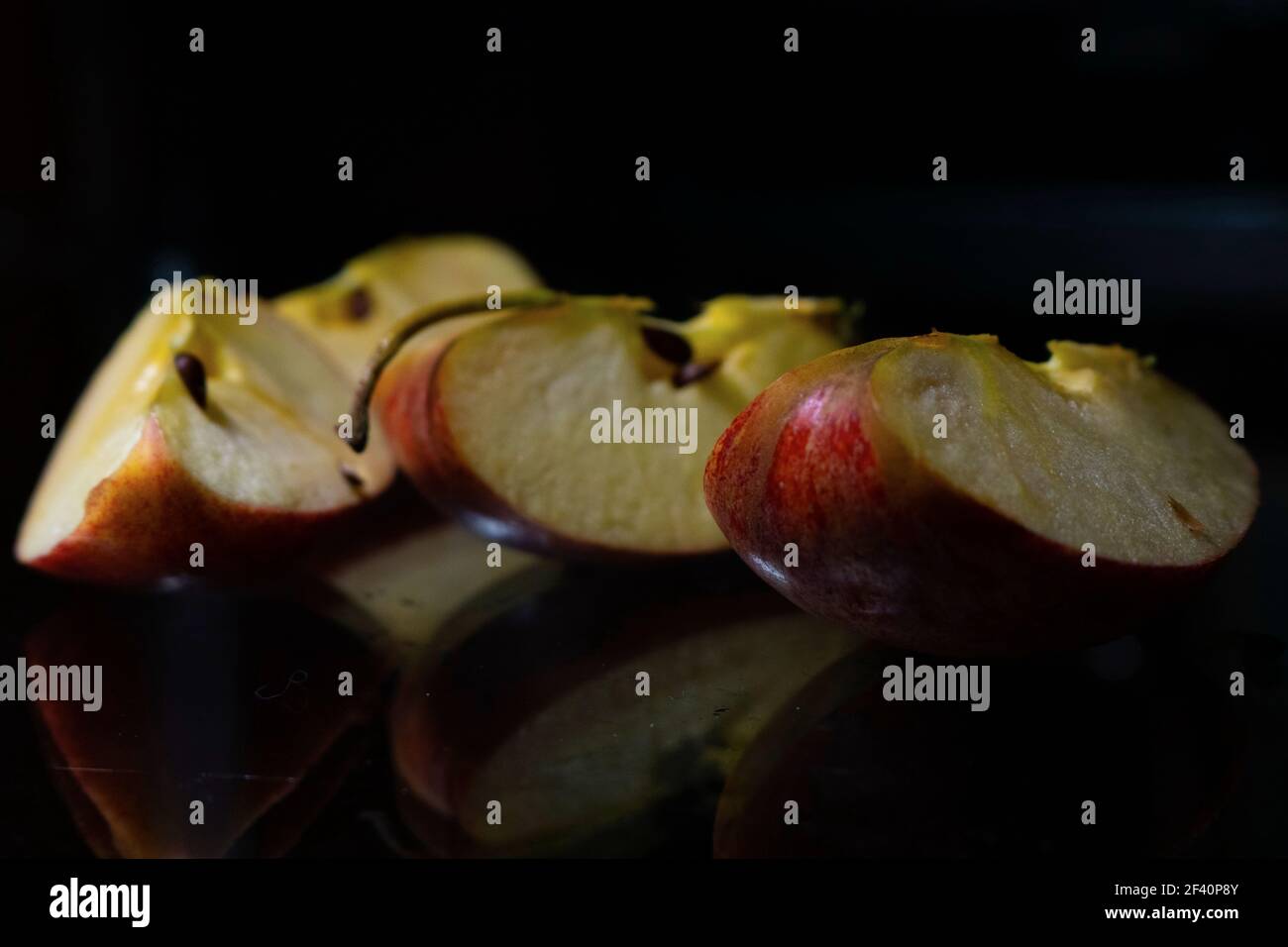 Red apple cut on black background with reflection Stock Photo - Alamy