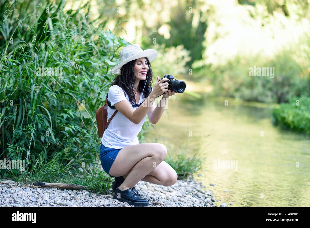 Beautiful hiker young woman taking photographs with a mirrorless camera ...