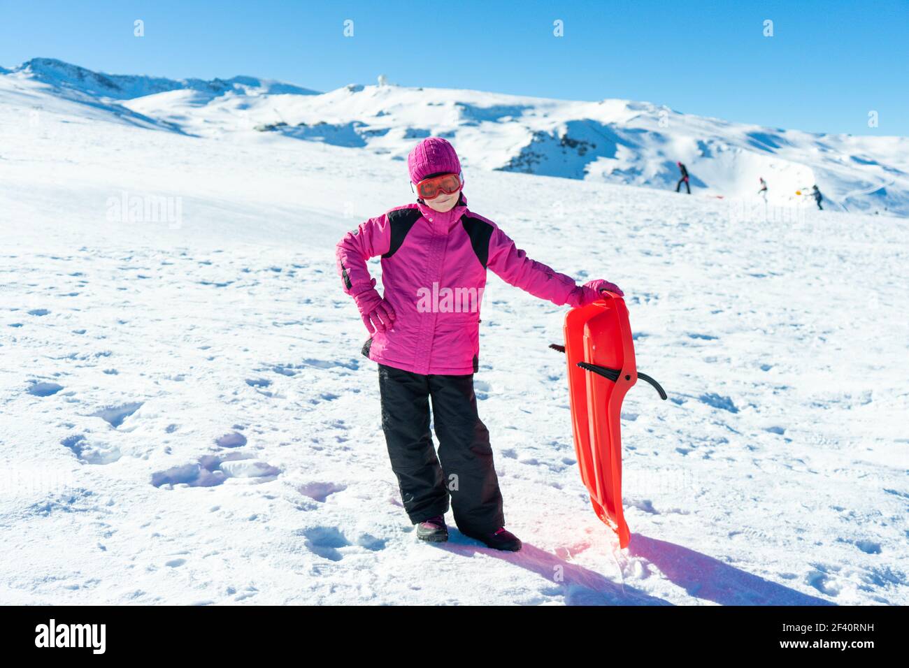 Little girl sledding at Sierra Nevada ski resort wearing snow clothes ...