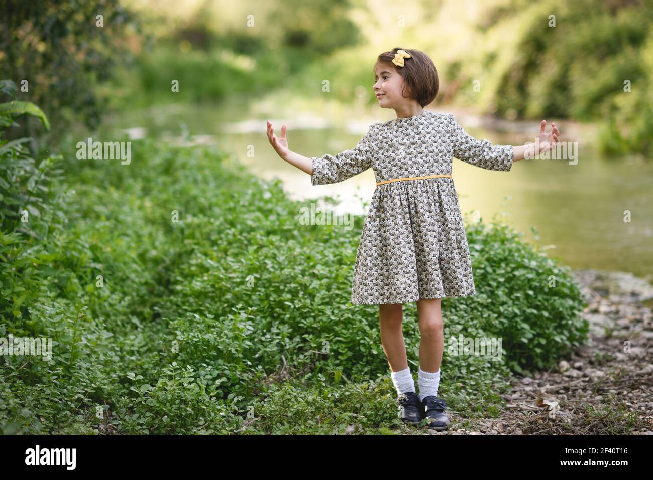 Little beautiful girl in nature stream wearing beautiful dress. Little ...