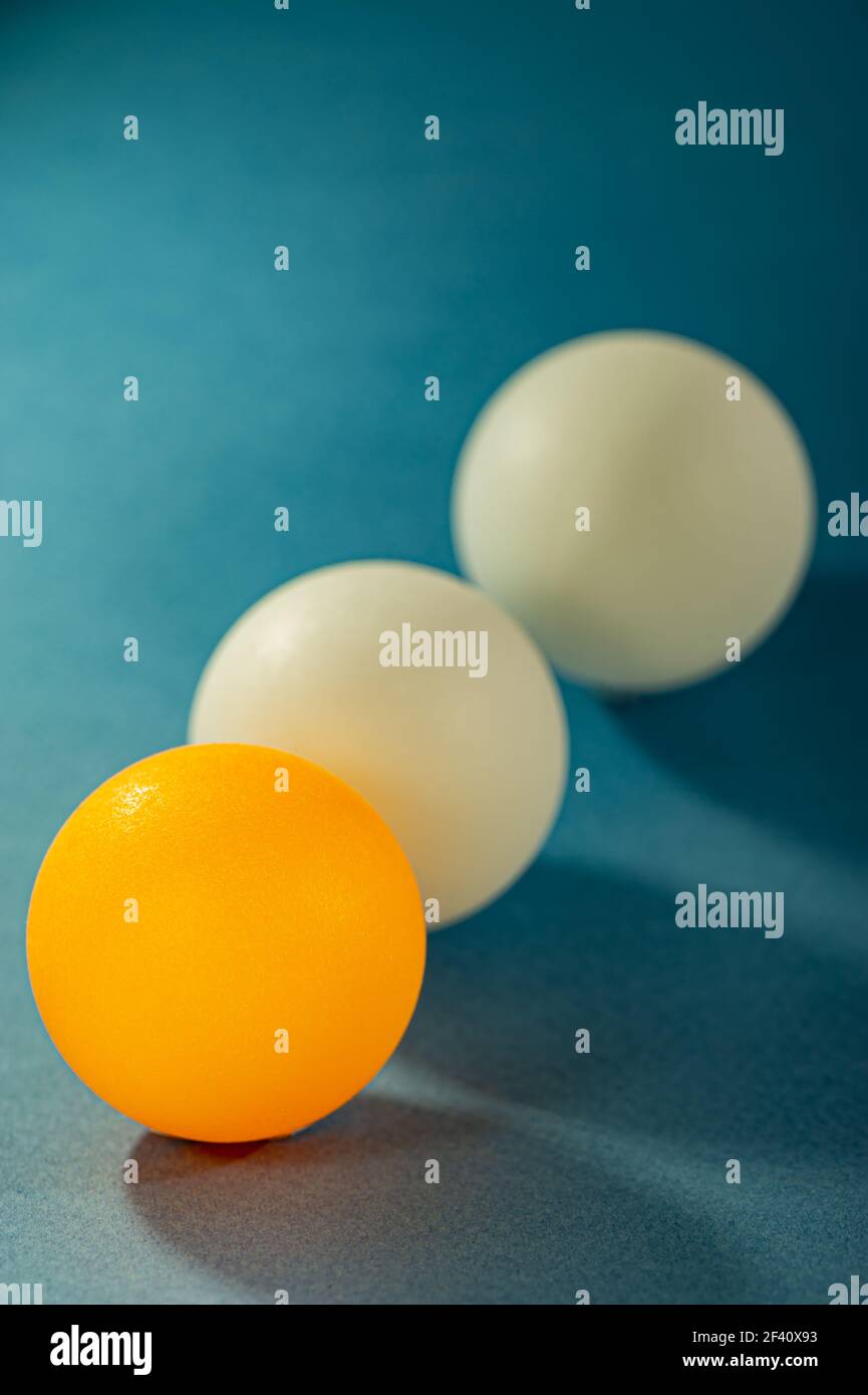 One orange ball and two white balls lie on a blue surface. Web banner ...