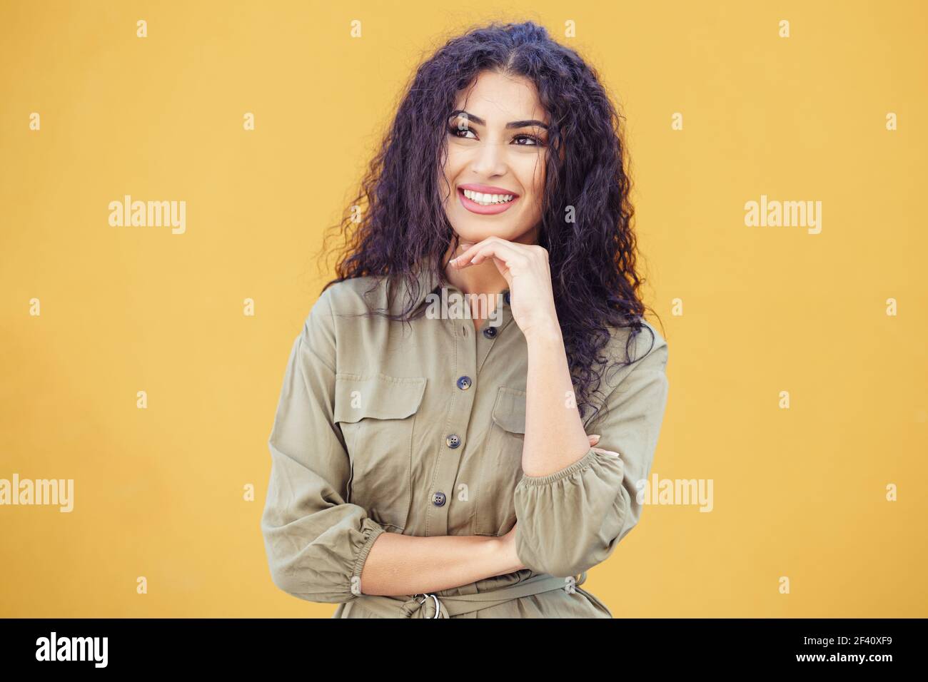 Thoughtful Arab Woman with curly hair in urban background. Young Arab ...