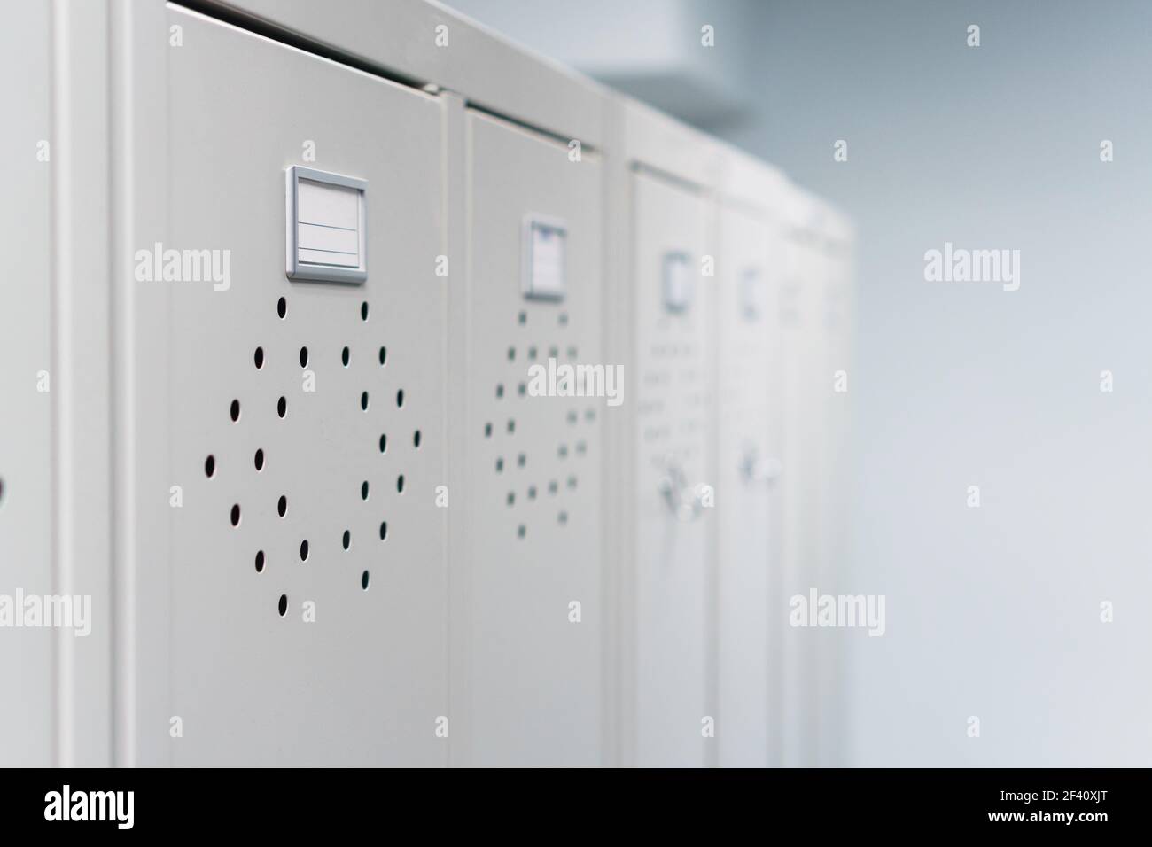 Gray metal lockers in the dressing room for clothes in a row. Storage ...
