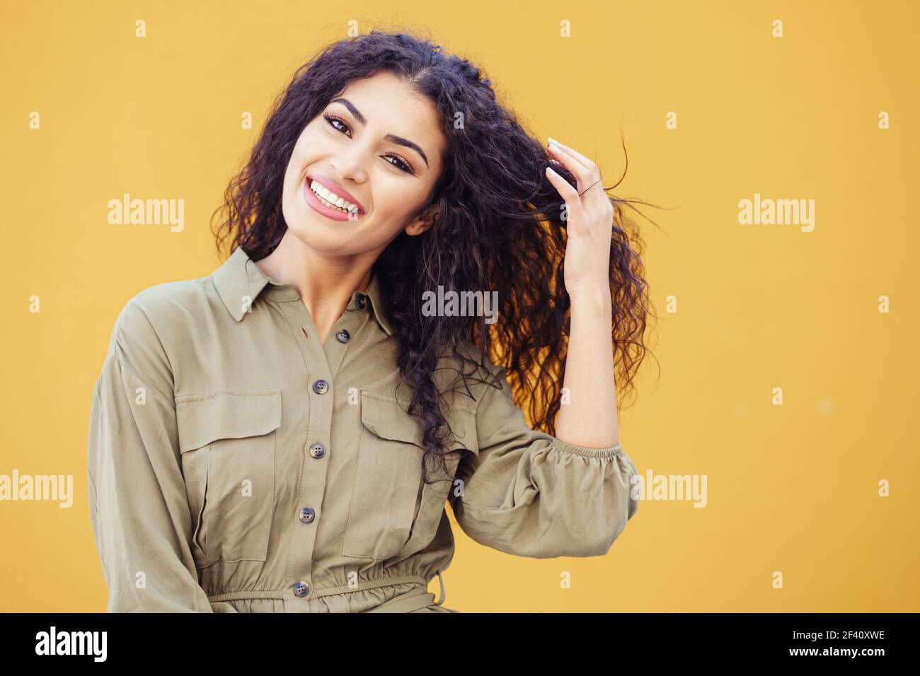 Happy Arab Woman with curly hair in urban background. Young Arab Woman ...