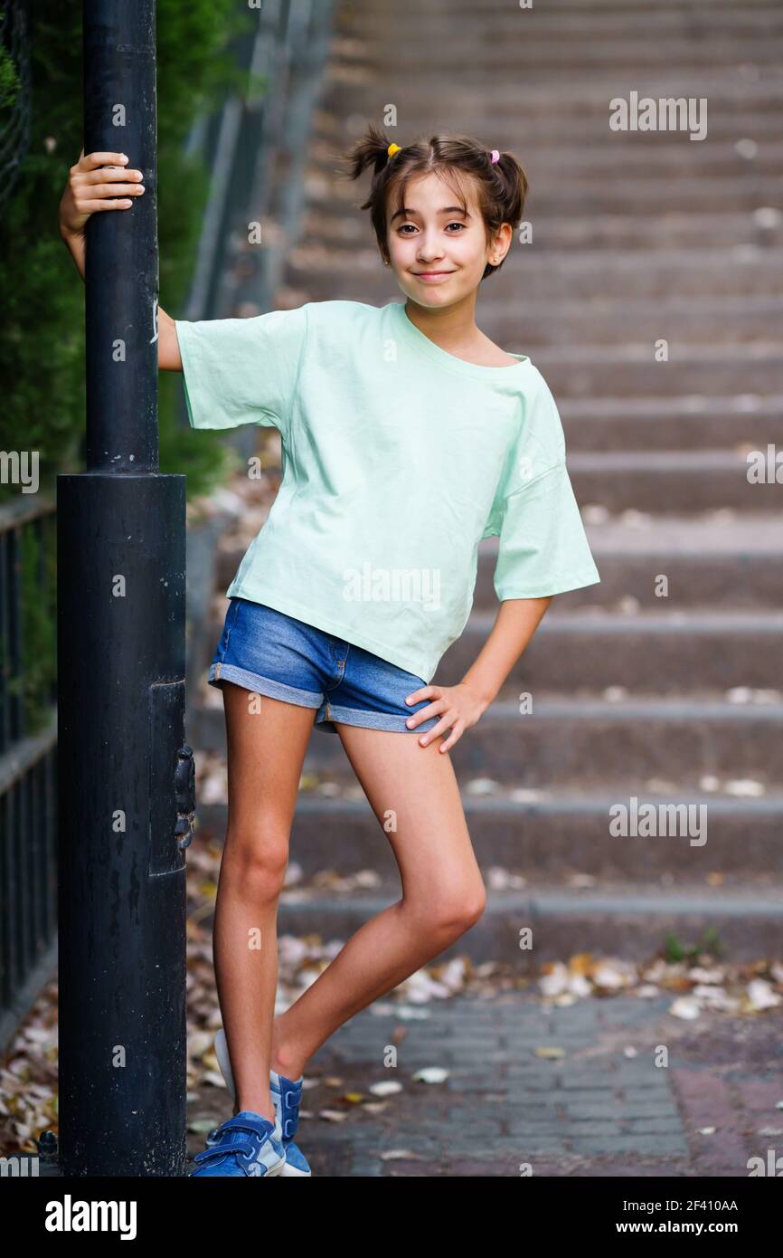Nine-year-old girl standing on the steps of a city park.. Nine-year-old ...