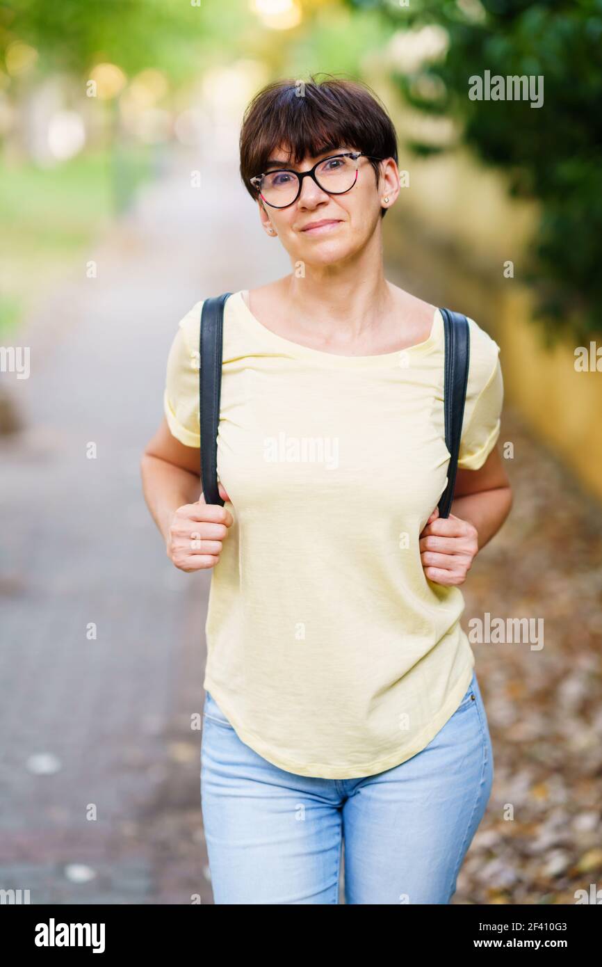 Middle-aged woman walking in a city park in summer. Beautiful Middle ...