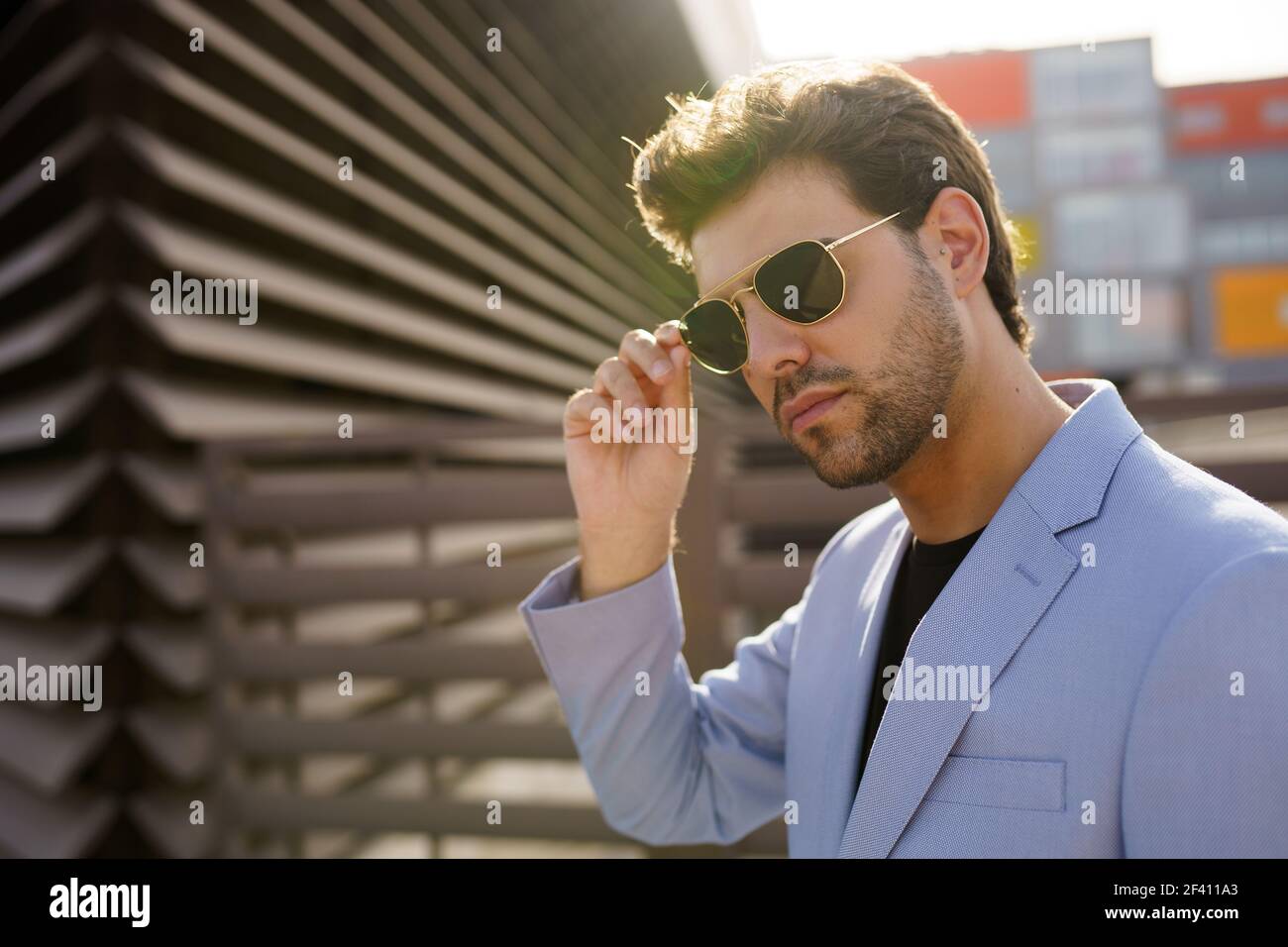 Young man, model of fashion, wearing sunglasses in urban background ...