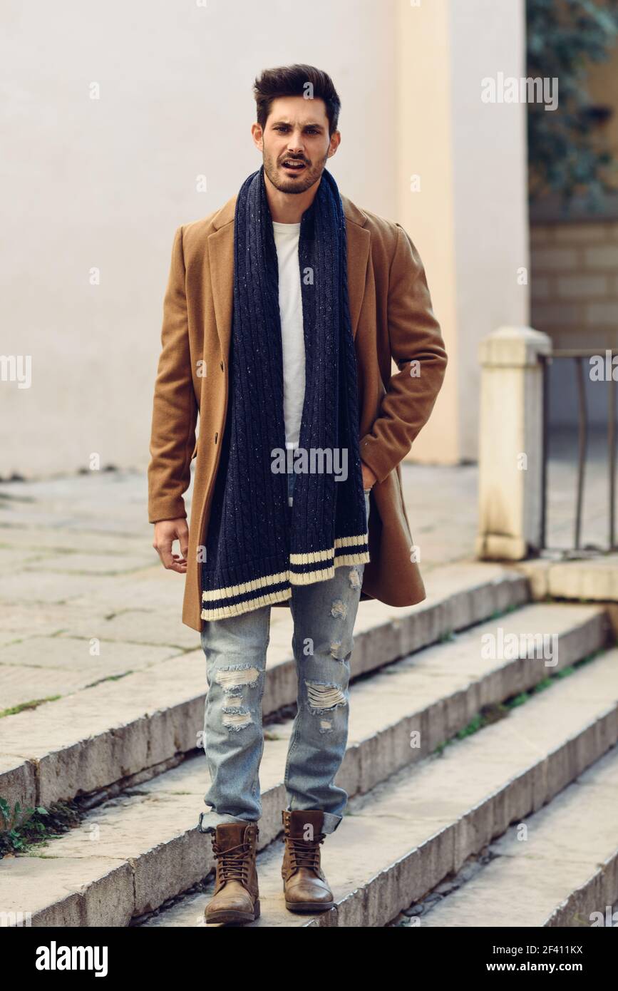 Young man wearing winter clothes in the street. Young bearded guy with ...