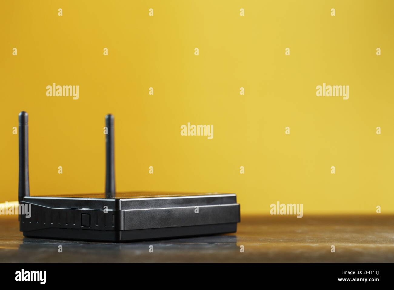 Black Wi-Fi router on a yellow background with free space. Isolate, top ...