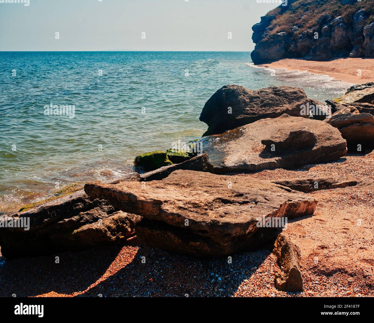 Daytime on rocky sea coast with deep blue sea and clear horozon line ...