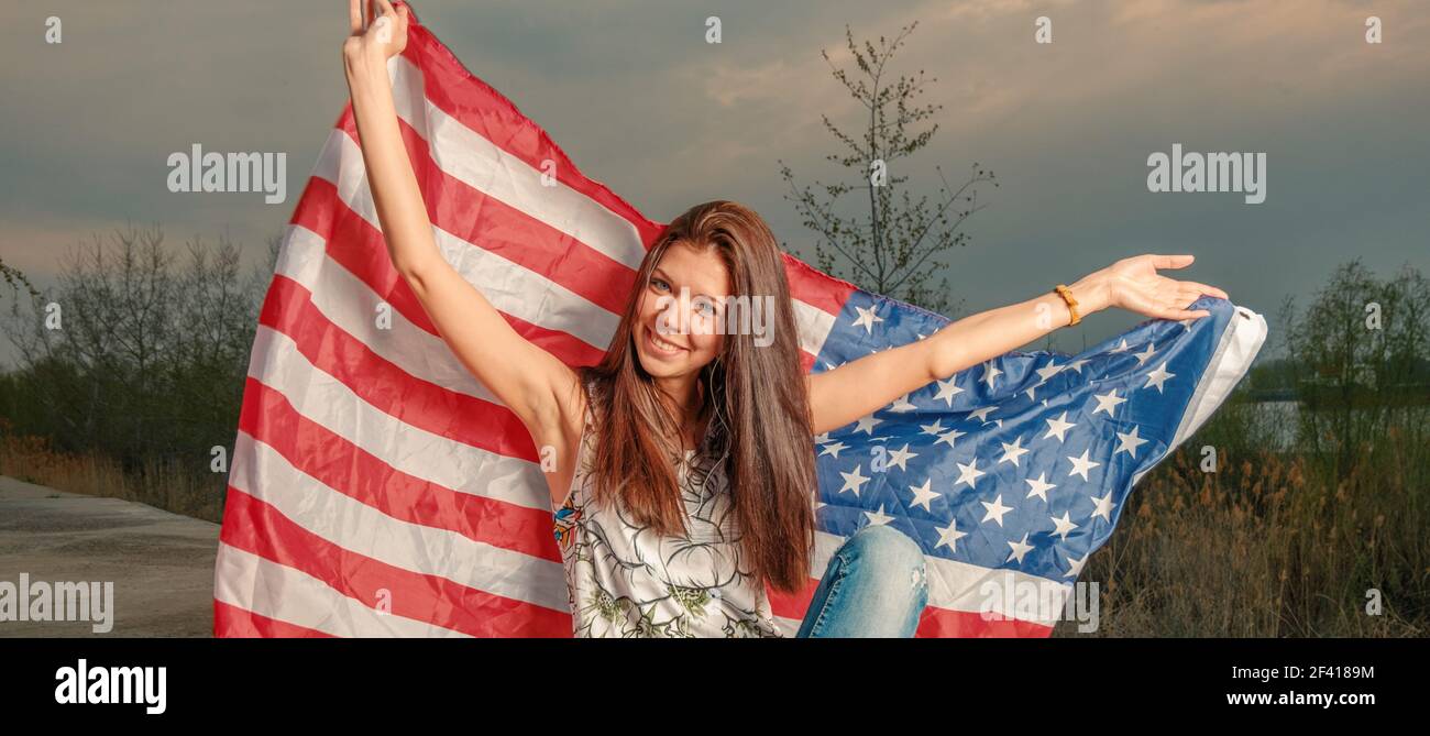 Happy girl with USA flag in her hands looking at camera, she is ...