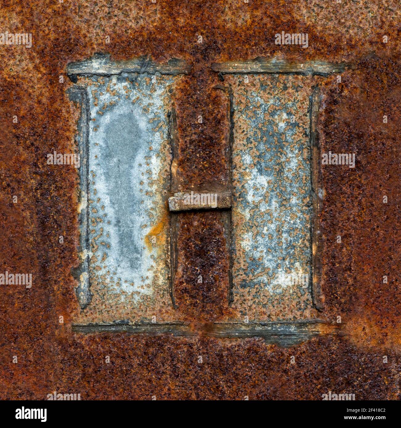 Remains of the letter H on rusty metal plate Stock Photo - Alamy