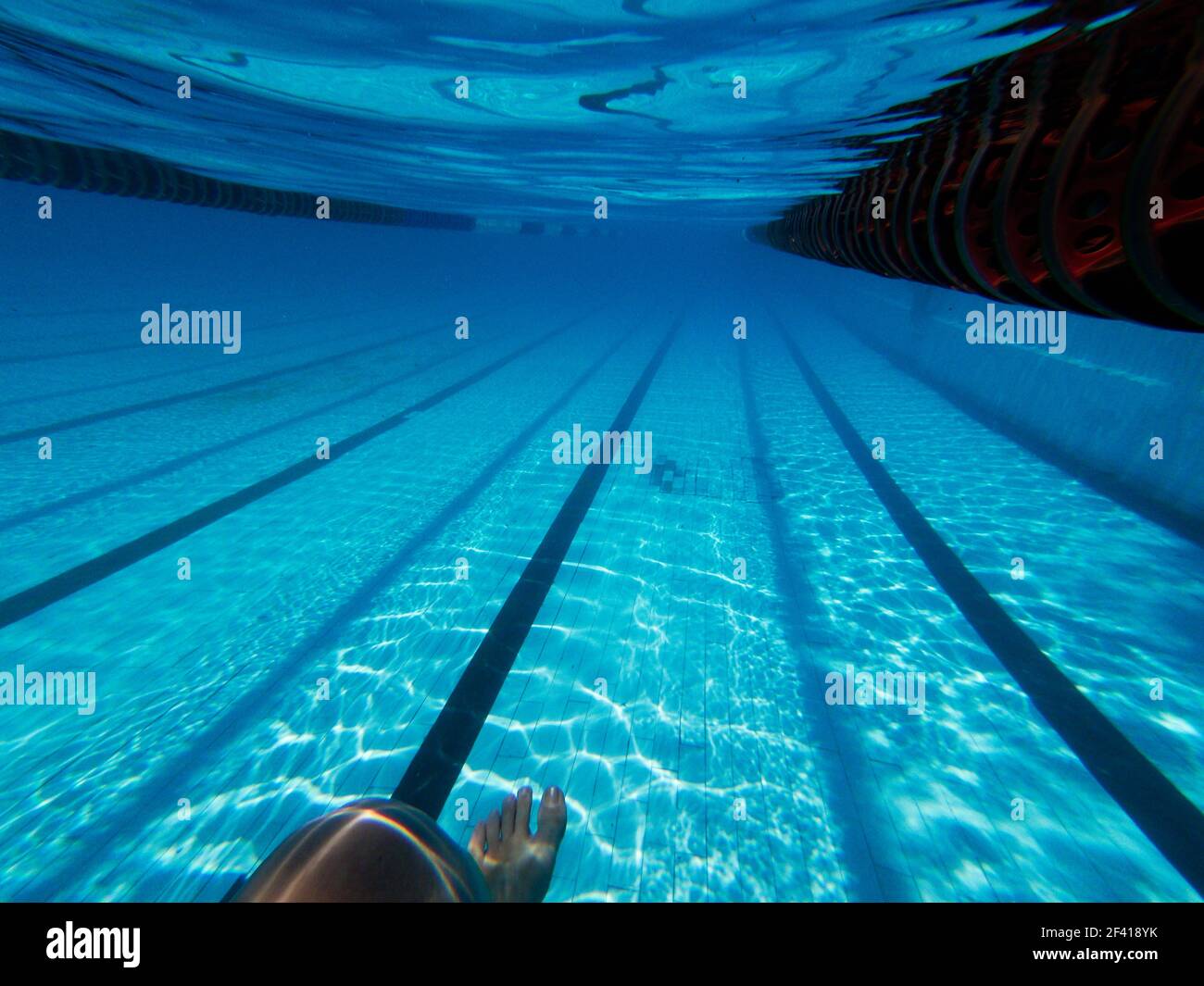 Underwater swimming pool shot with womans leg near pools bottom ...