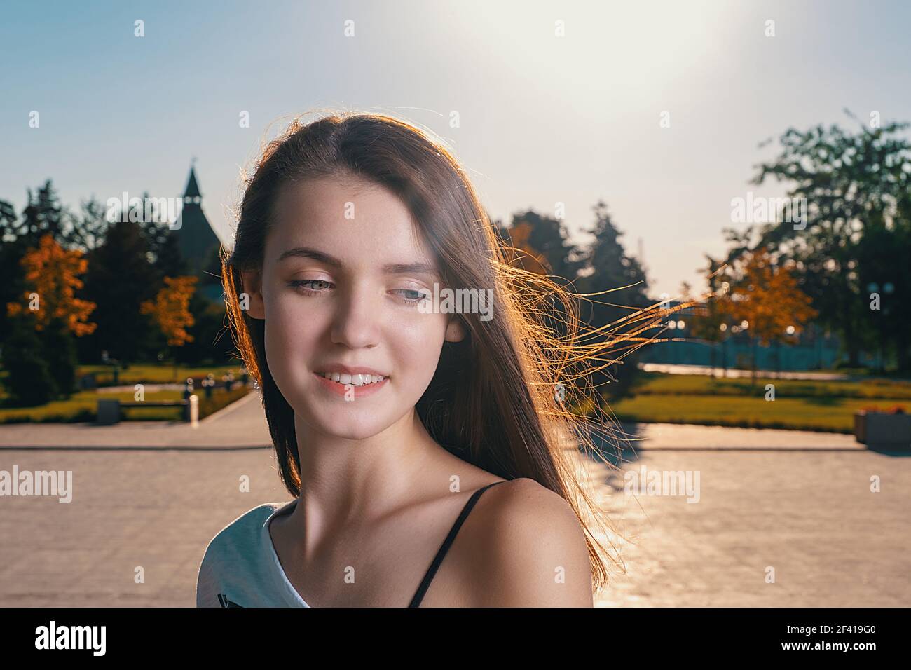 Happy Cute Girl looking down in summer day backlit. Cute girl looking ...