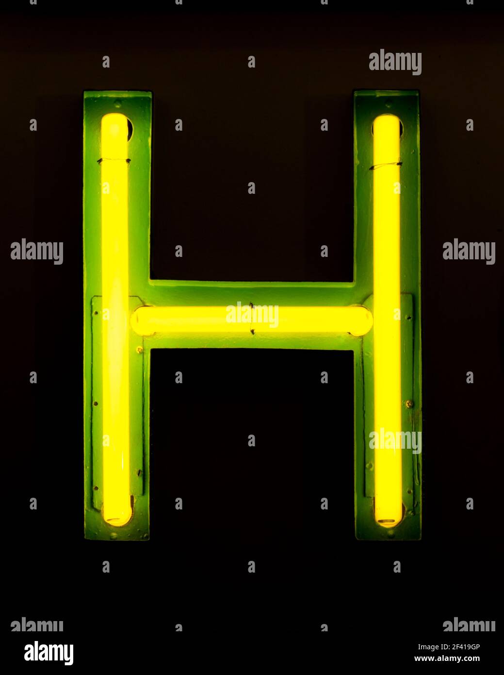 Yellow neon letter H glowing in the dark Stock Photo - Alamy