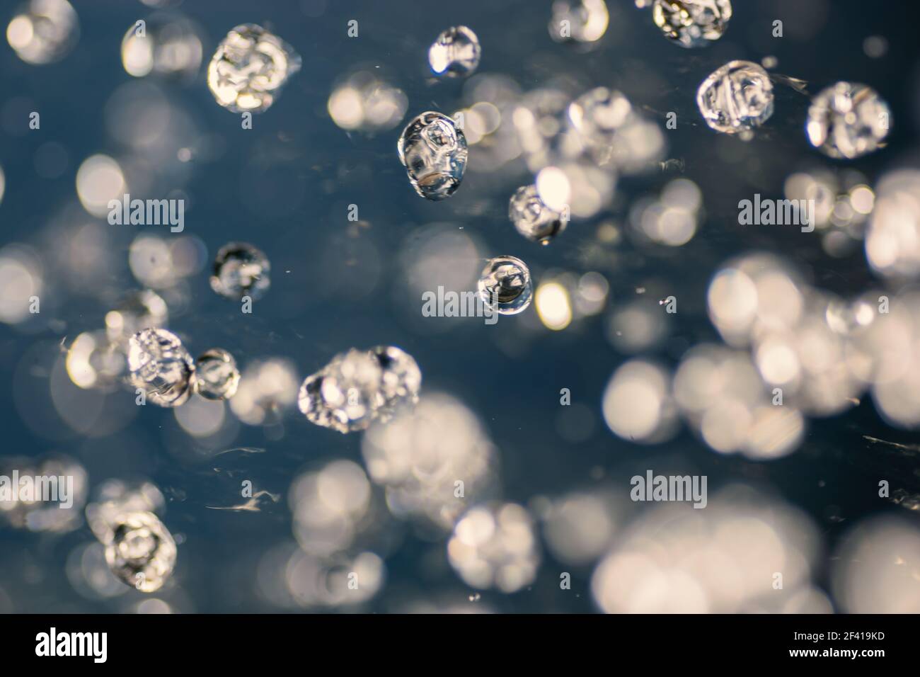 Round water drops levitation on blue background Stock Photo - Alamy