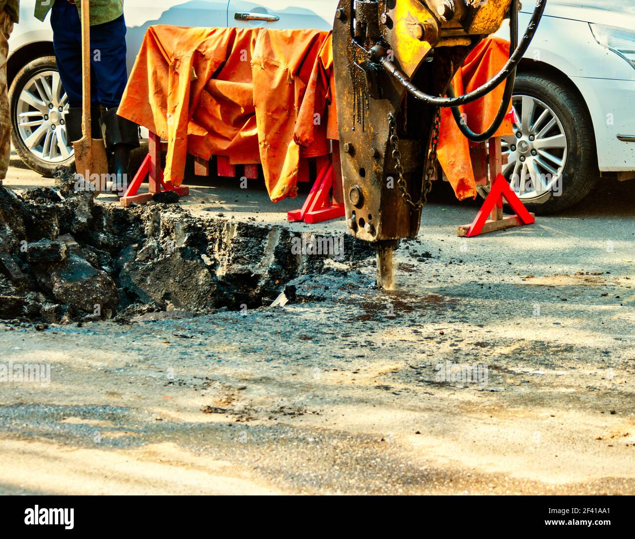 Construction machine destroy the asphalt surface of the road, repair ...