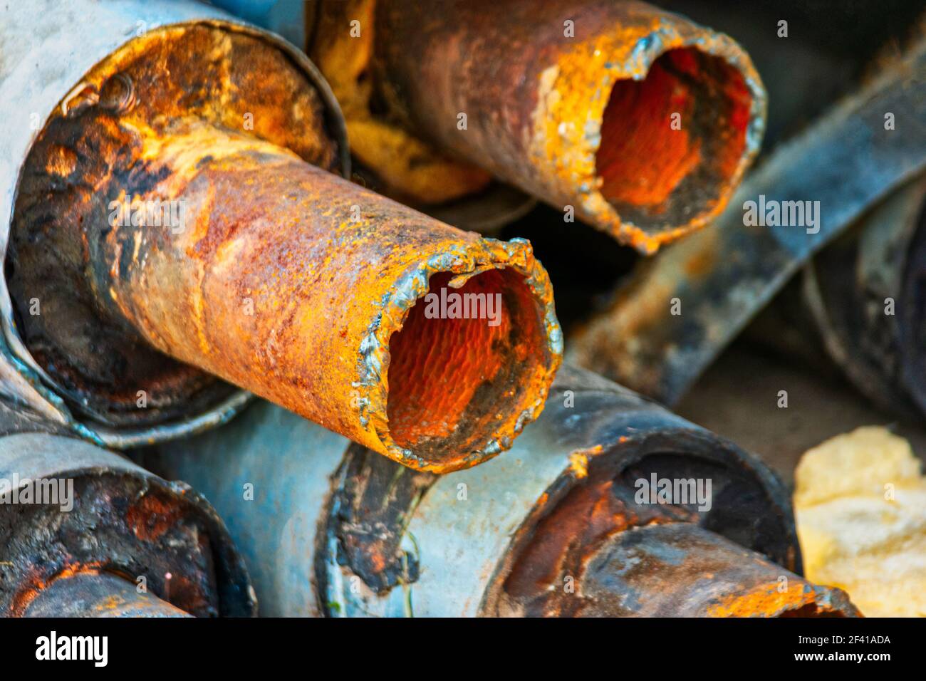 Closeup of Stack of corroded steel pipes with worn thermal insulation ...
